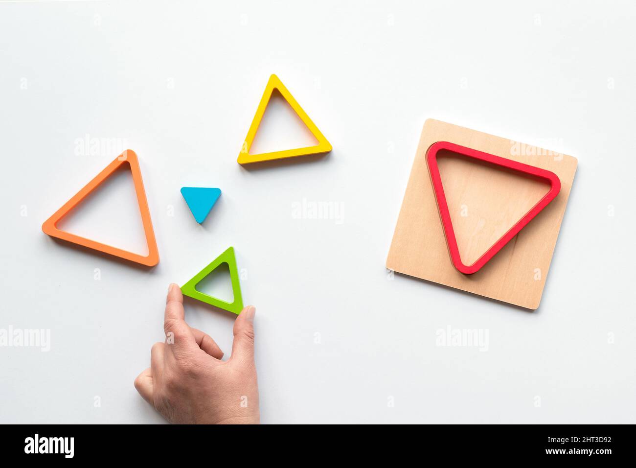 Nested wooden triangles painted in rainbow colors. Flat lay on white ...
