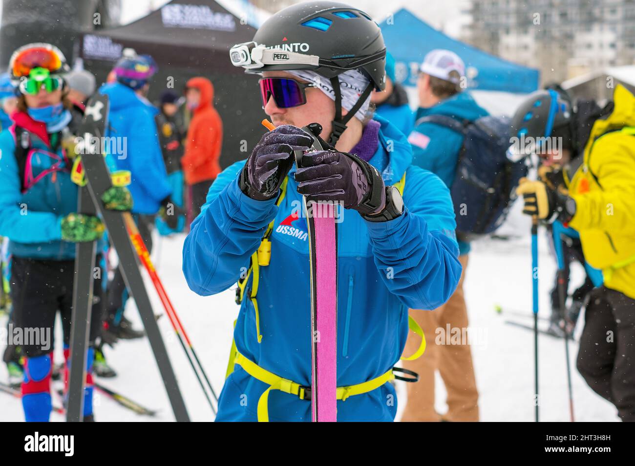 February 25, 2022: A SKIMO racer applies climbing skins to his skis ...
