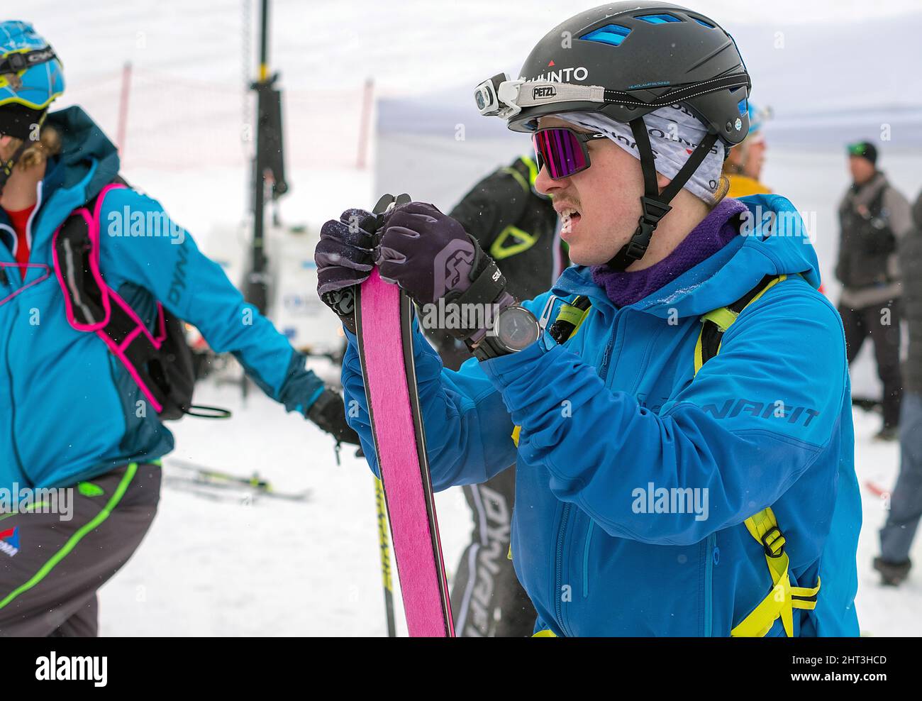 February 25, 2022: A SKIMO racer applies climbing skins to his skis ...