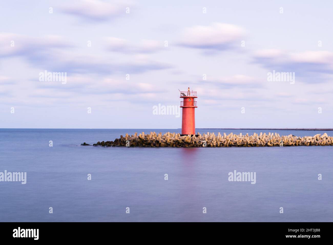 Red lighthouse on an isolated island on the sea to guide the sailors ...