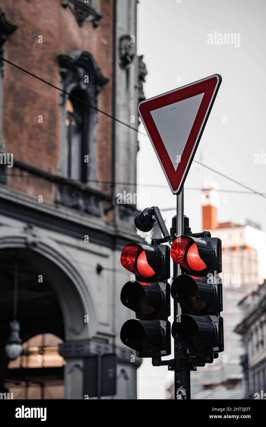 Vertical shot of the traffic lights and a road sign "give way" in the ...