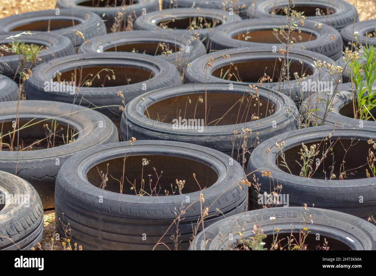 Closeup of car tires arranged on the ground in the yard for recycling ...