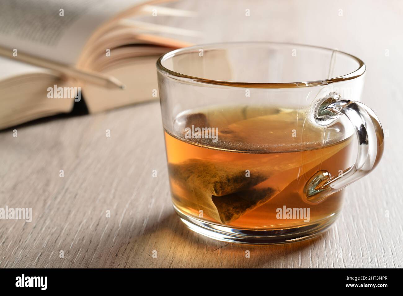 Tea in glass cup and open book. Tea time Stock Photo - Alamy