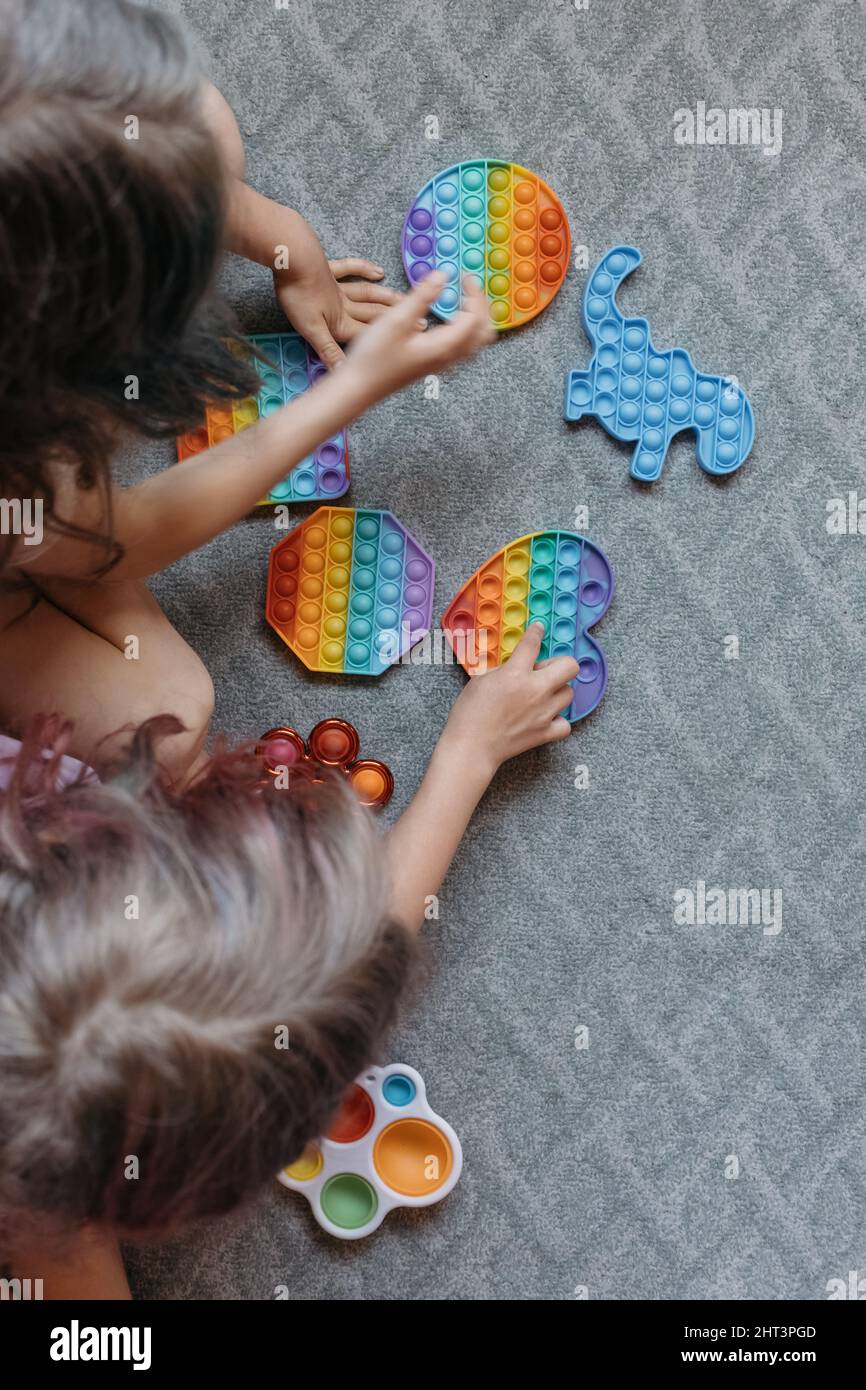 View from above to children playing with pop it toys Stock Photo - Alamy