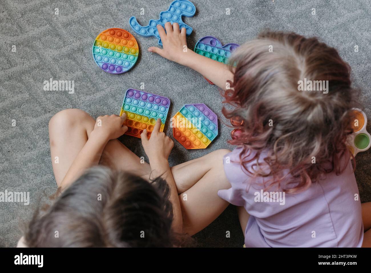 View from above to children playing with pop it toys Stock Photo - Alamy