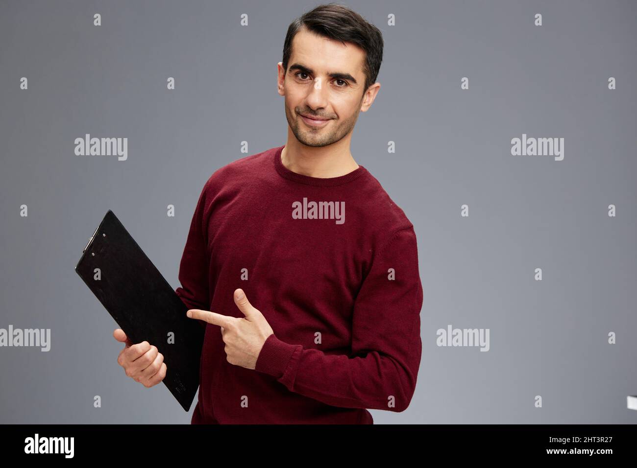 manager with a smile points a finger at a notepad in a sweater posing ...