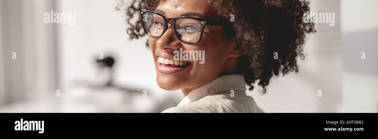 Smiling pretty lady sitting at her workplace and holding phone Stock ...