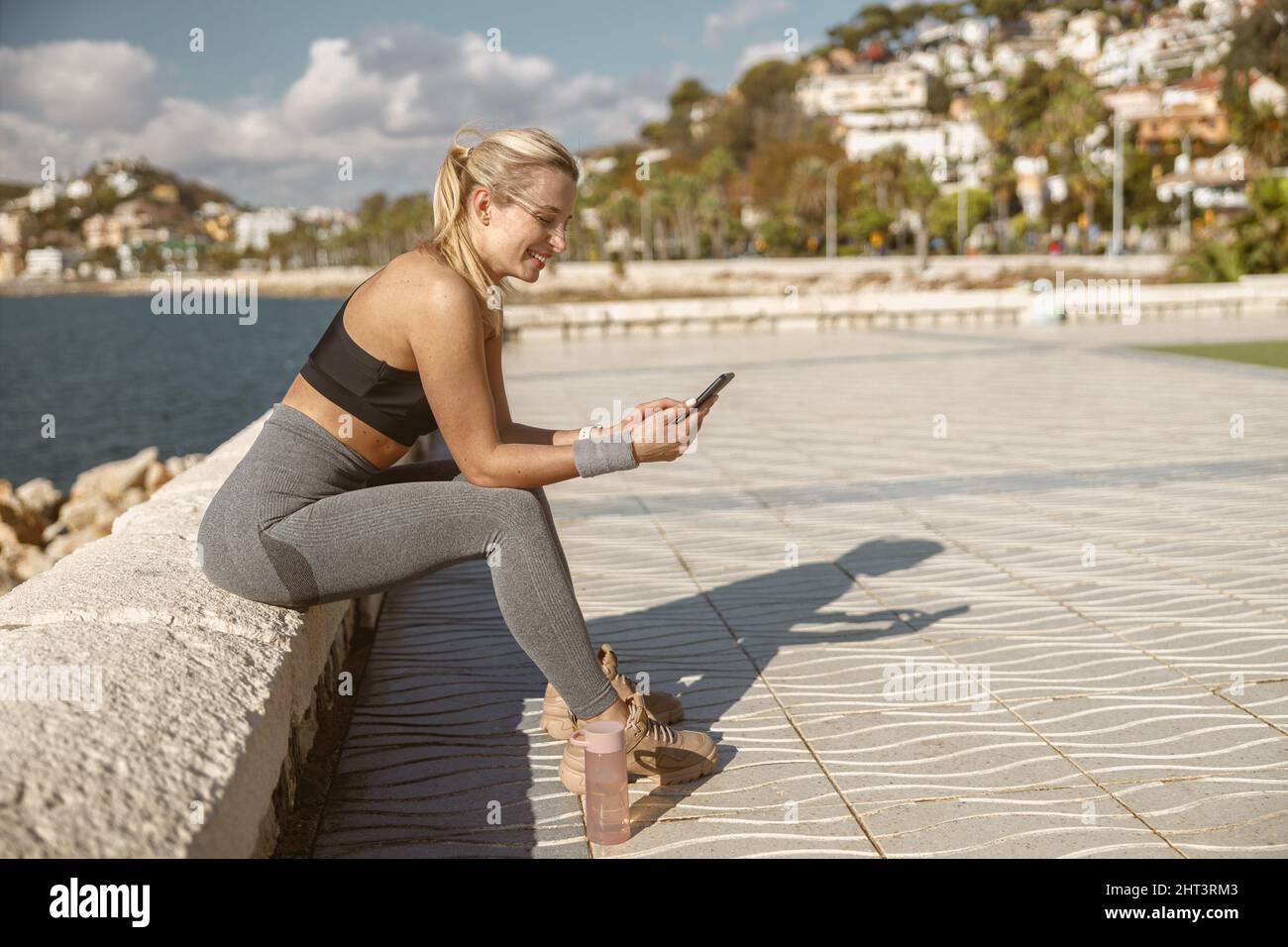 Pretty woman relaxing after workout at seashore Stock Photo - Alamy