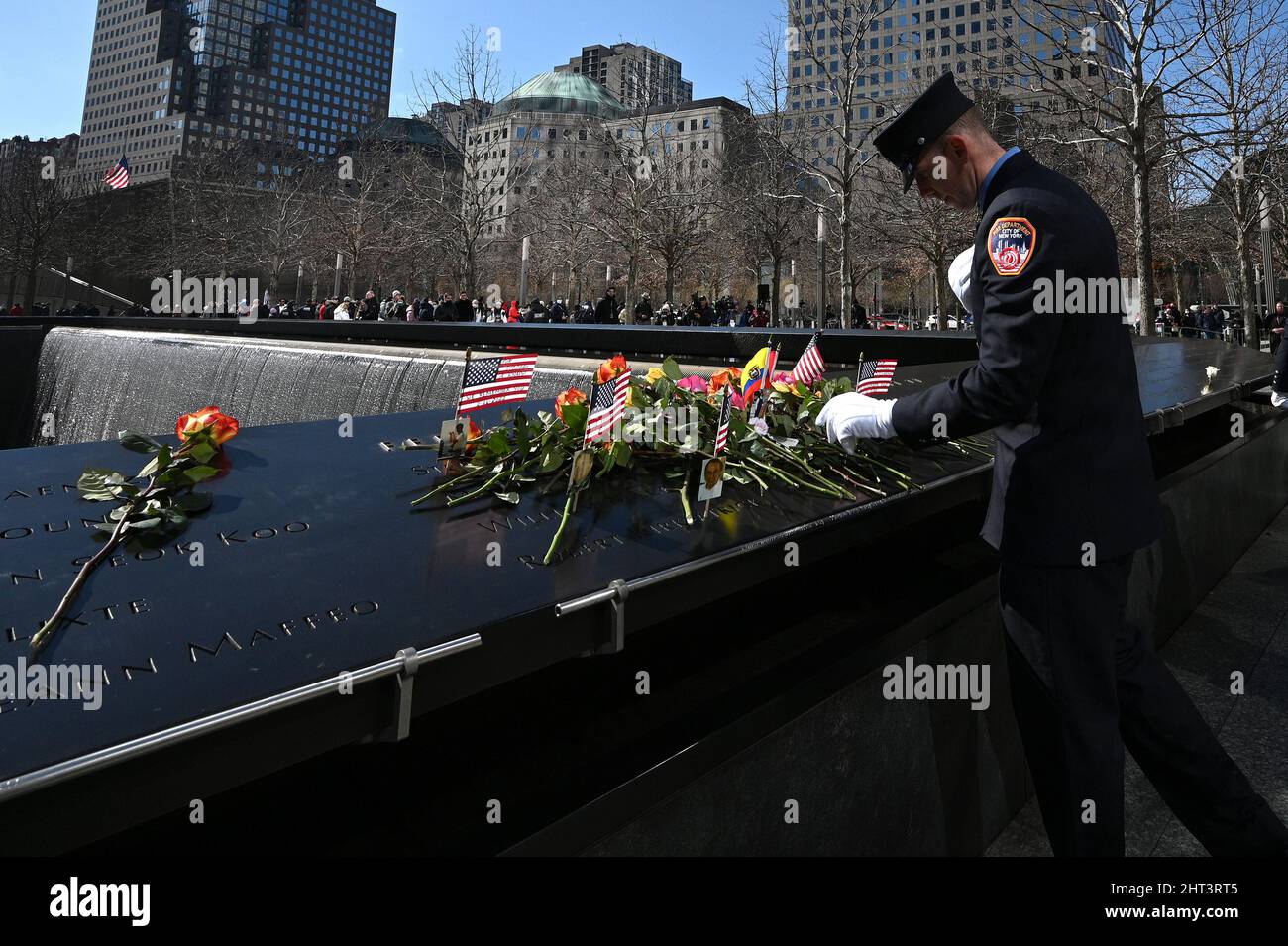 A member of the FDNY crosses himself as he places a flower on the ...
