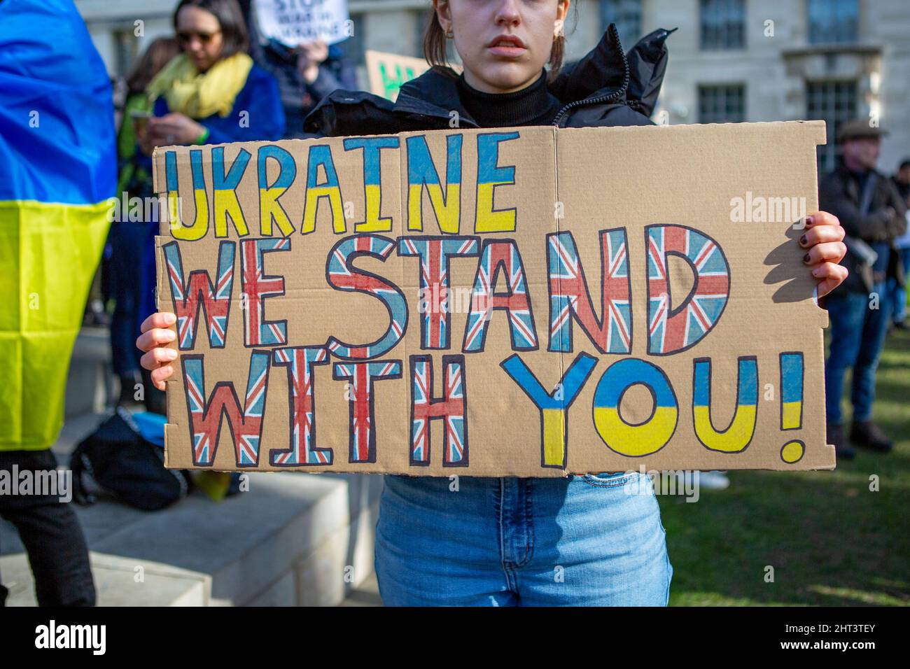 London, UK. 26th Feb, 2022. A Protester holds a placard expressing her ...