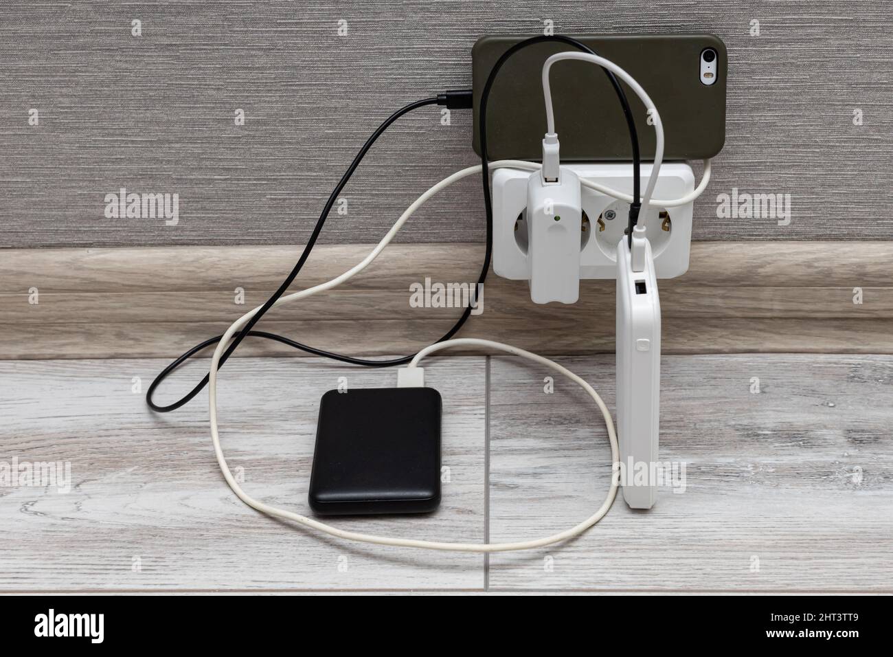 electrical outlet to which the power bank and smartphone are connected ...