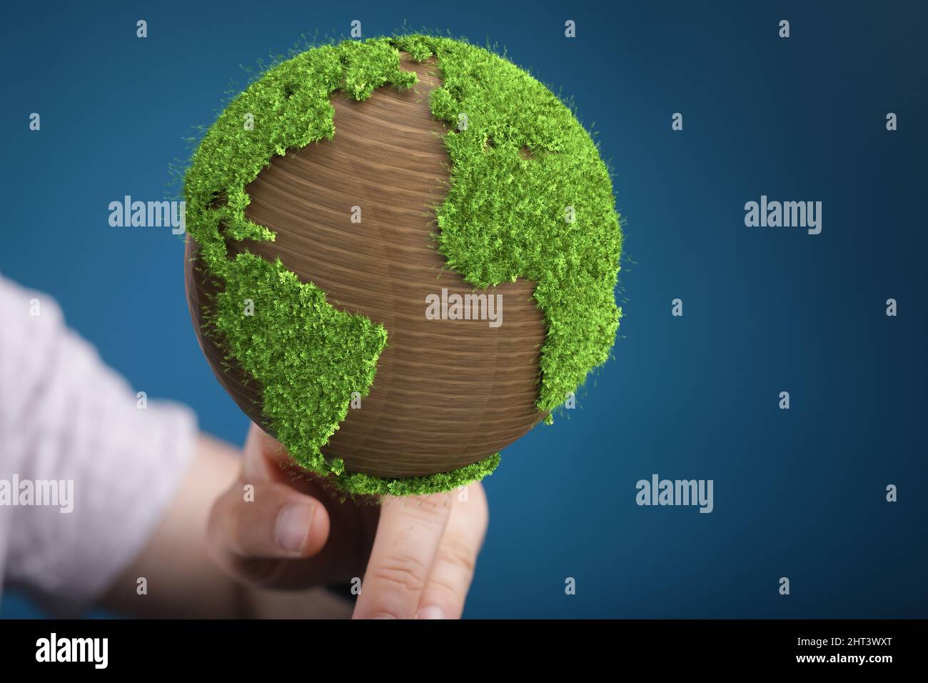 Finger holding a small globe made out of green thread and recycled ...