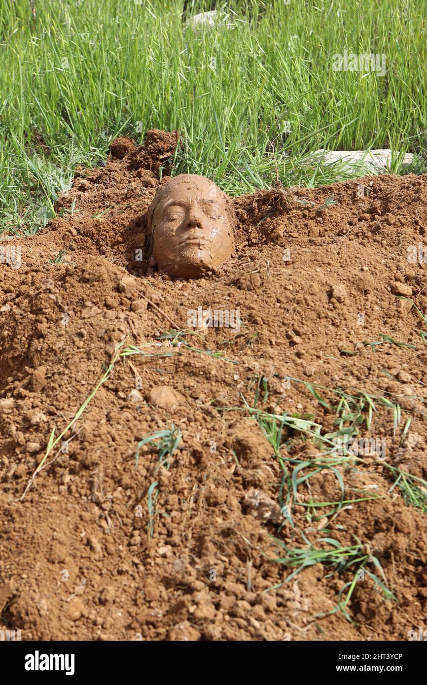 A woman buried in the ground A face covered in the ground Stock Photo ...