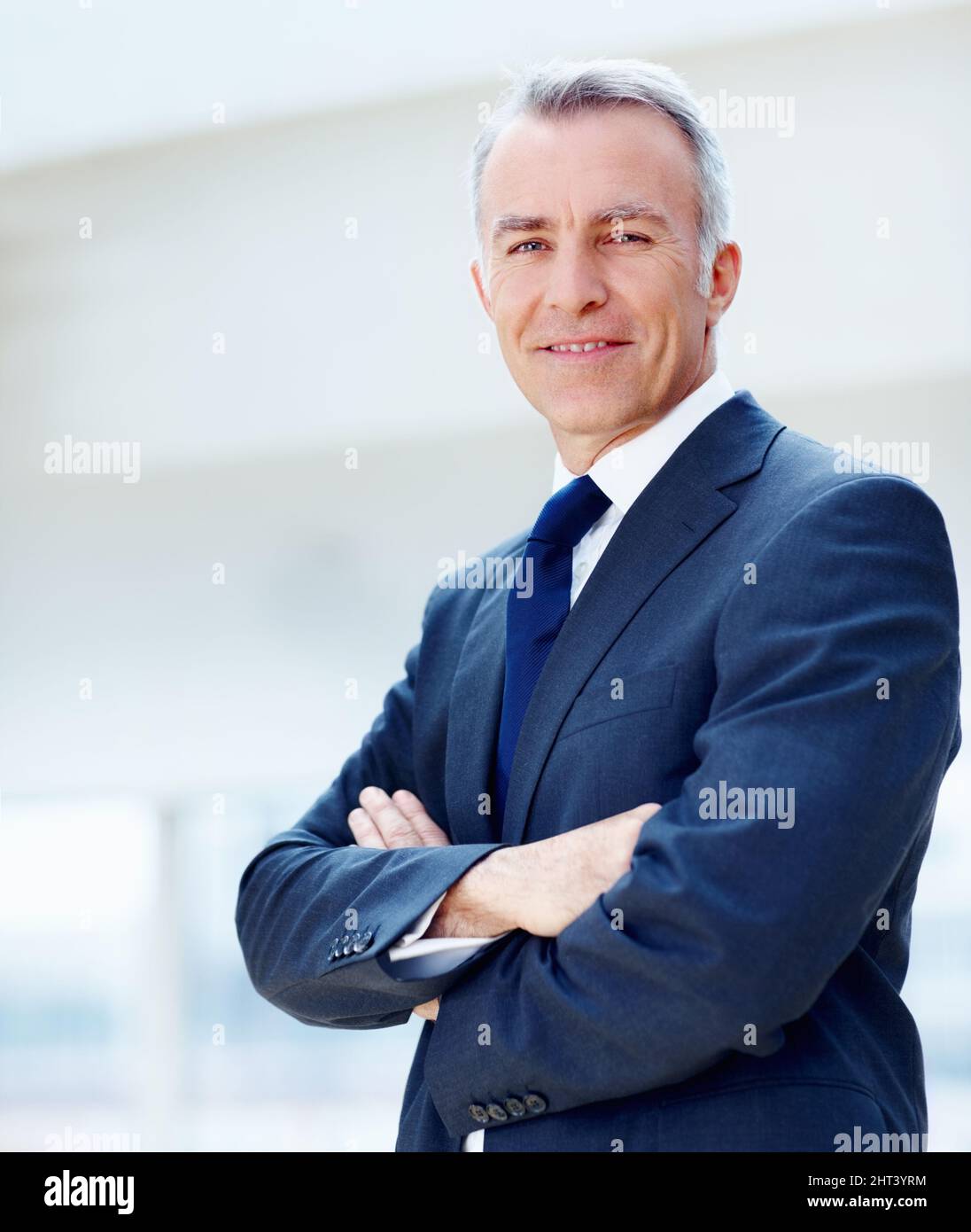 Successful businessman. Executive standing with arms folded Stock Photo ...