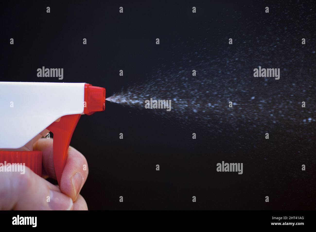 Finger pushing a spray isolated on a black background Stock Photo - Alamy