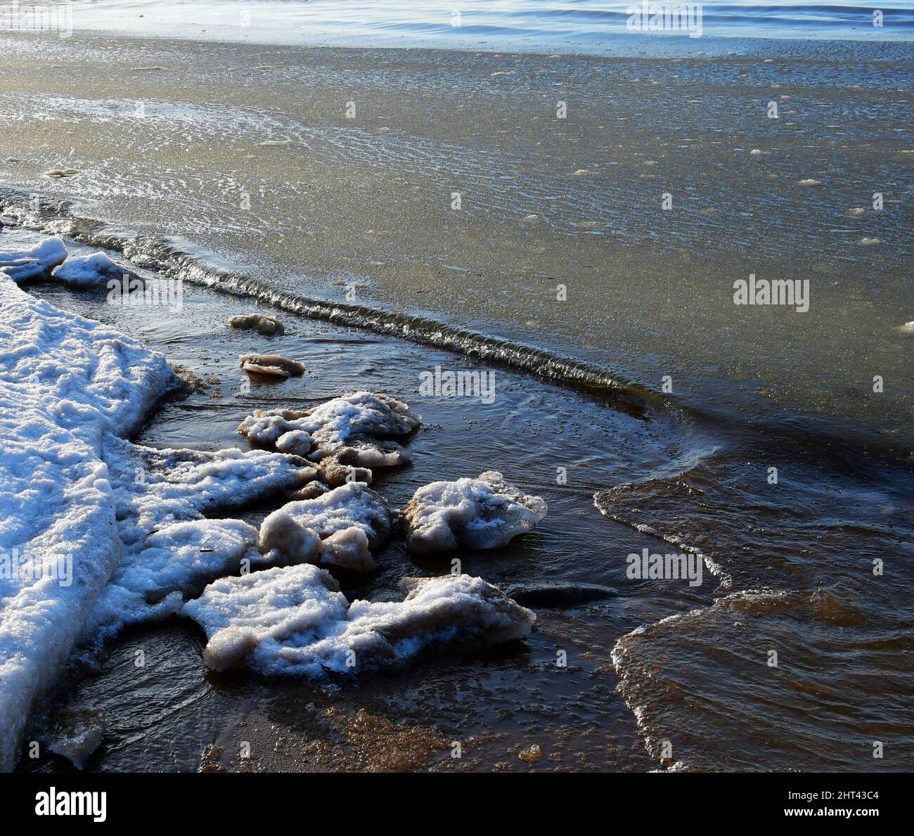 High angle shot of frozen glaciers, stones, rocks, and land on a sea ...