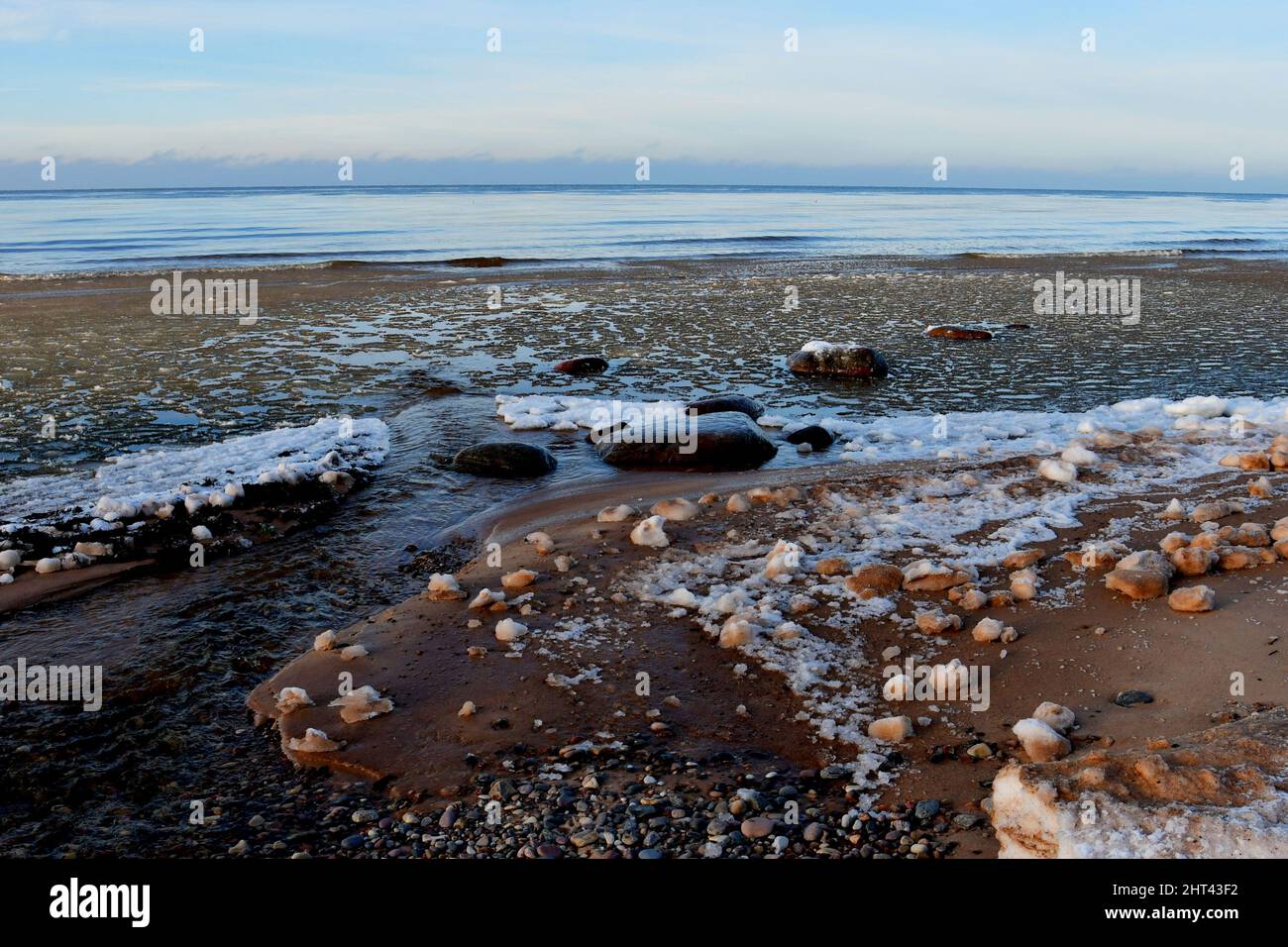 High angle shot of frozen glaciers, stones, rocks, and land on a sea ...