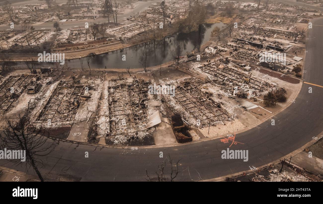 Street running through a mobile home park ruined by arson wildfire ...