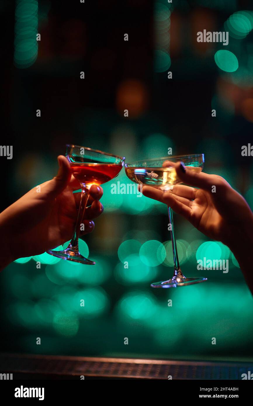 Celebrating with glasses of alcohol in hands. Happy female friends ...