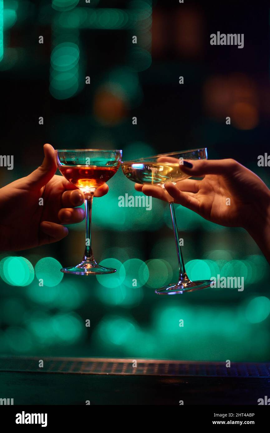 Celebrating with glasses of alcohol in hands. Happy female friends ...