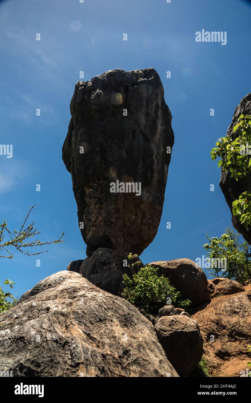 Vertical shot of a huge balanced rock on other rocks in the daytime ...