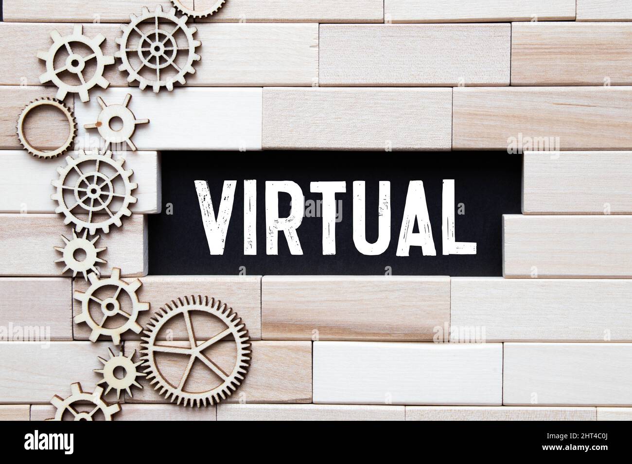 The word VIRTUAL is written on a wooden block on a computer keyboard ...