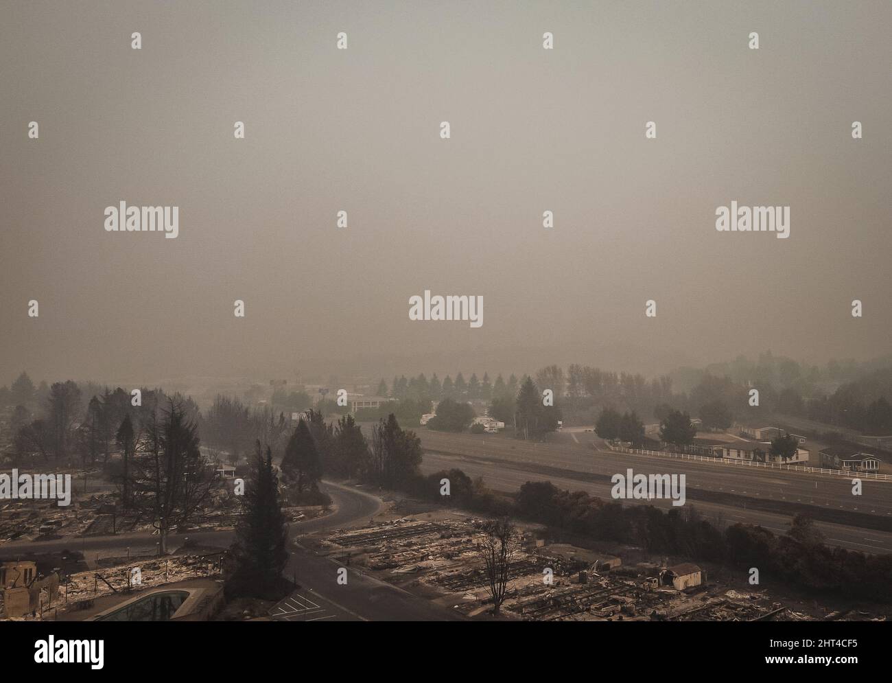 Smoke filled skies overlooking the aftermath and tragedy of a wildfire ...