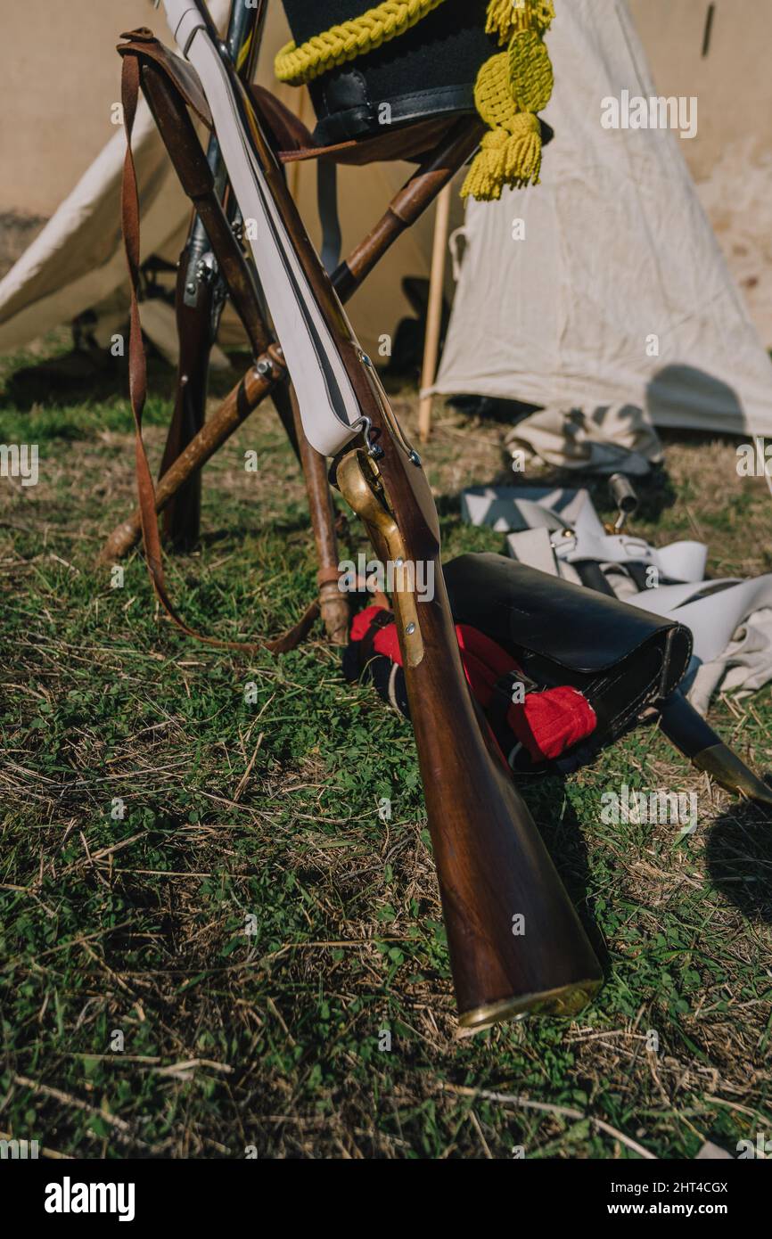 Photo of a gun on the grass with weapons and other army objects in the ...