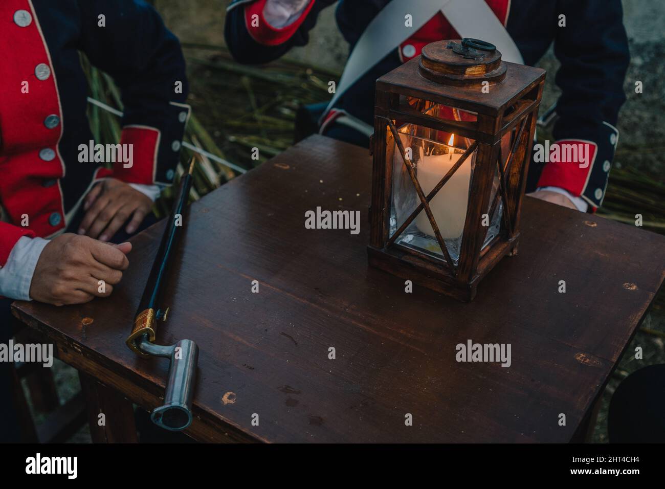 Photo of two soldiers sitting around a wooden table with a candle ...