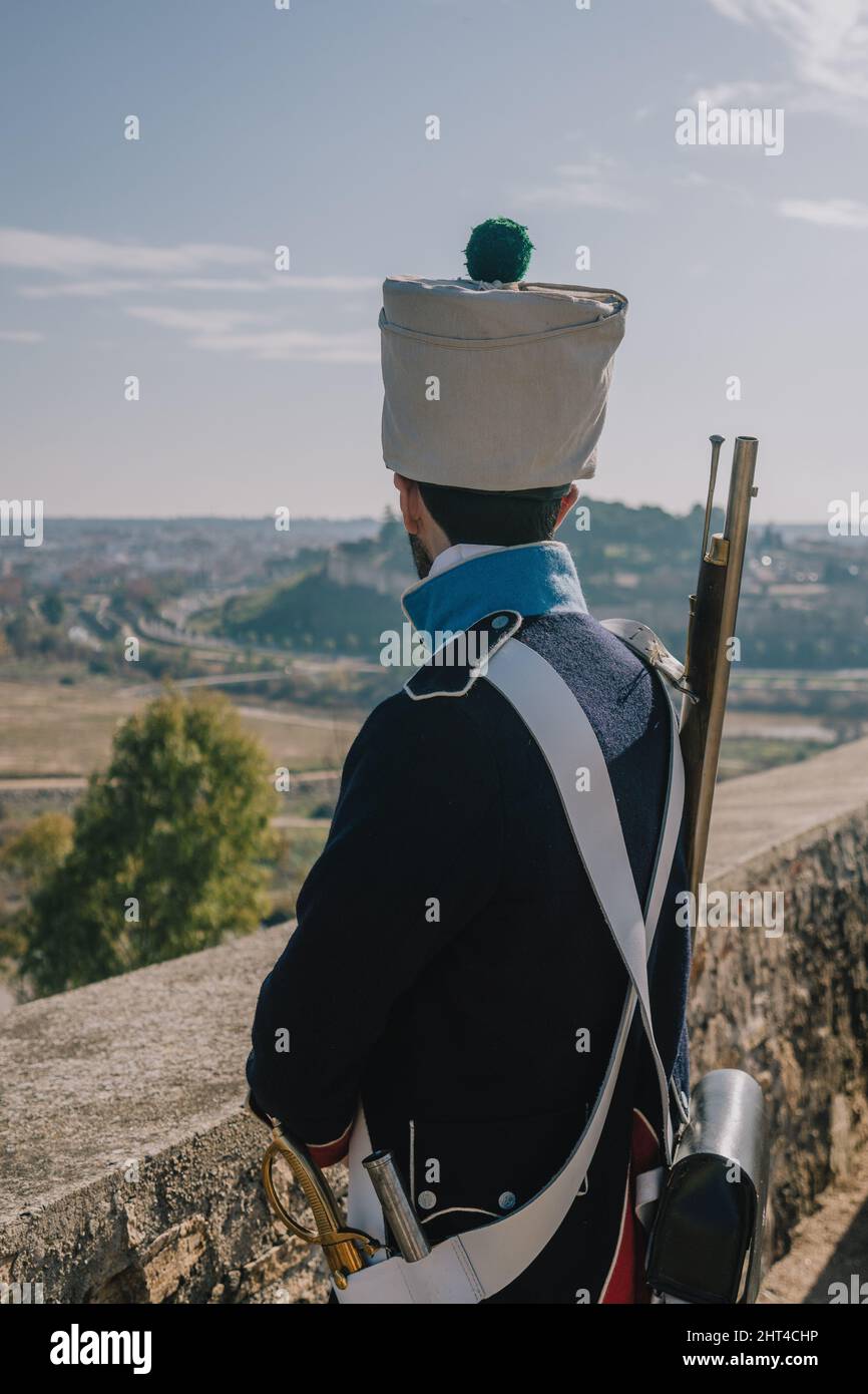 Vertical photo of a soldier from behind standing alone and guarding an ...