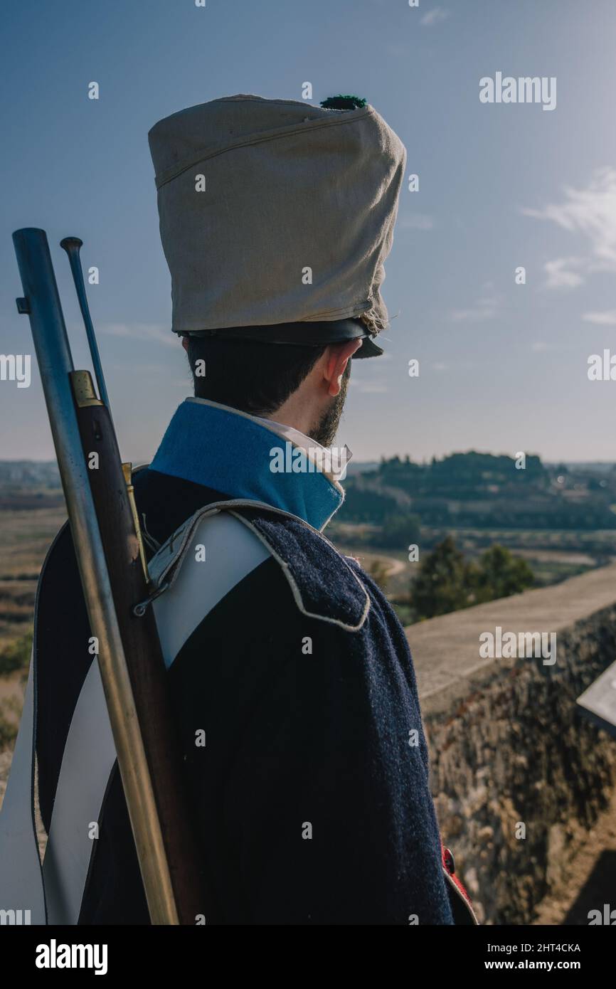 Vertical photo of a soldier from behind standing alone and guarding an ...