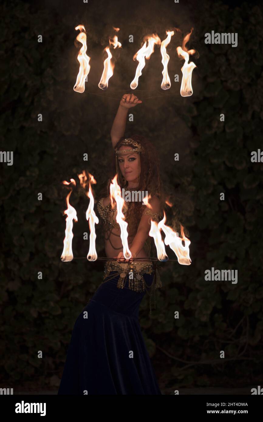 Attractive Caucasian female in a costume posing with fire fans Stock ...