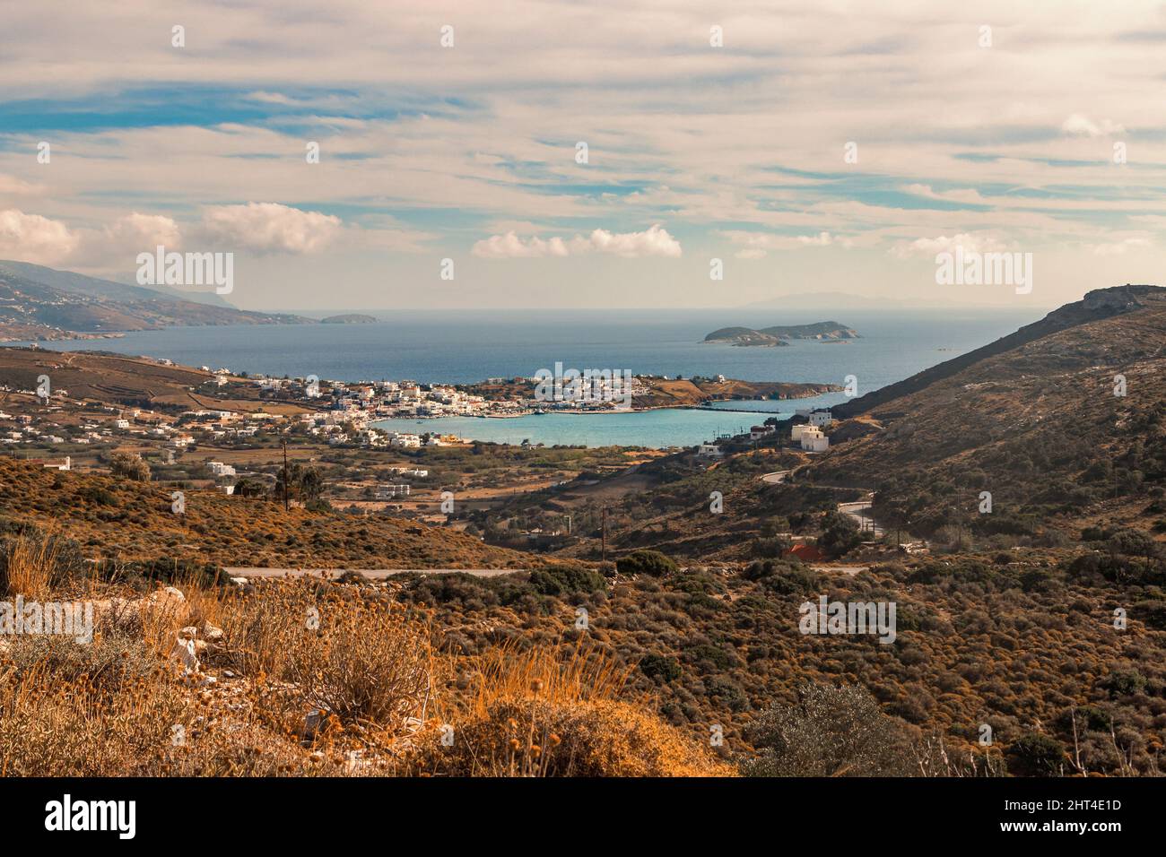 Landscape of the port of Gavrio under a blue cloudy sky and sunlight in ...