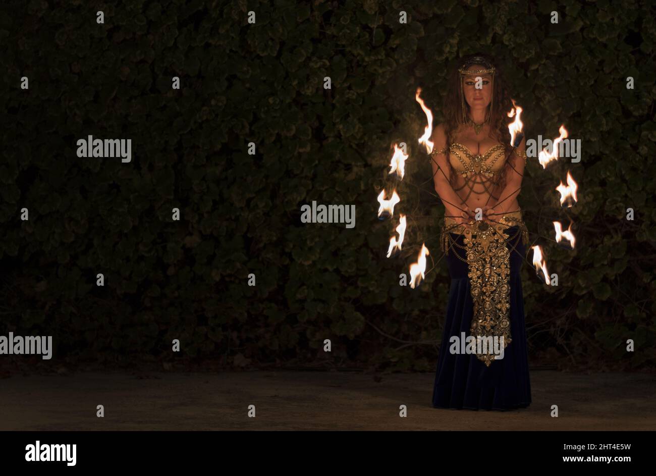 Attractive Caucasian female in a costume posing with fire fans Stock ...