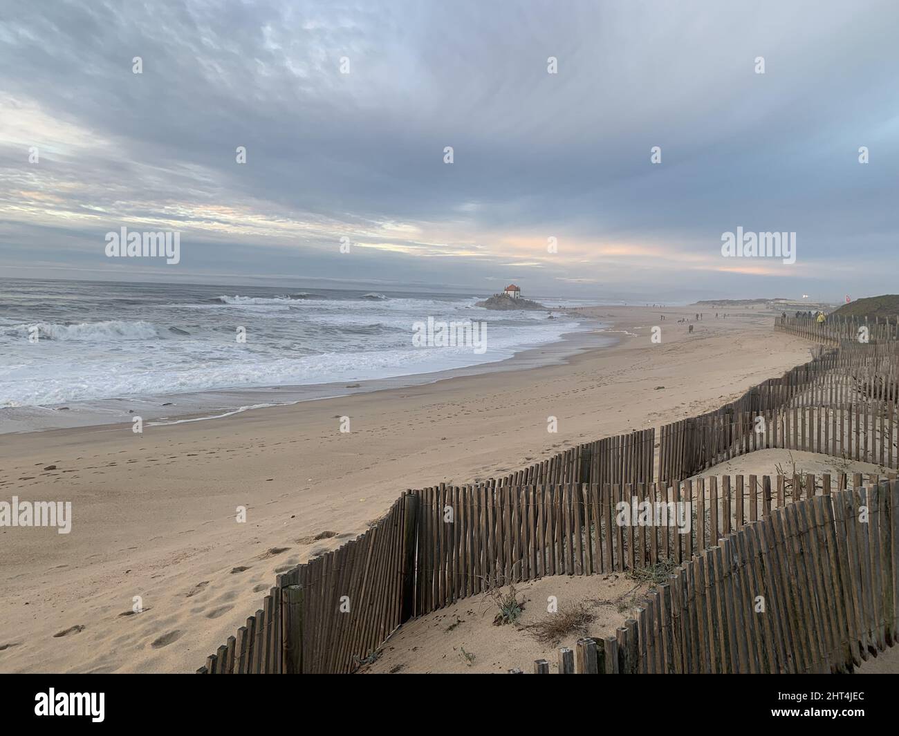 Dune fencing on a sandy beach during sunset Stock Photo - Alamy