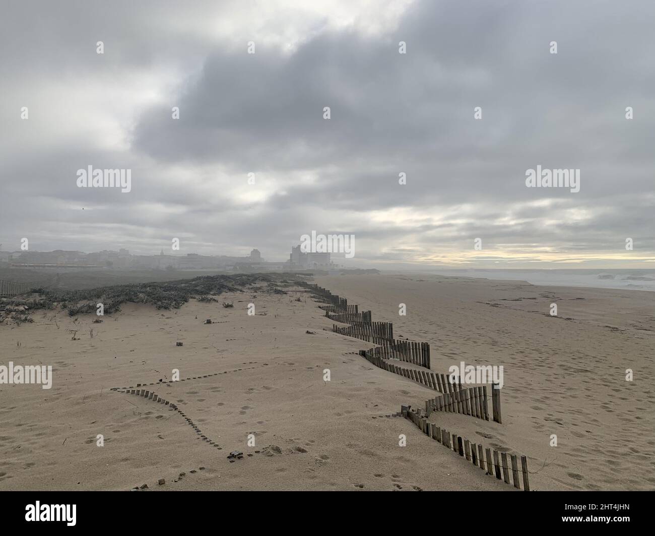 Dune fencing on a sandy beach during sunset Stock Photo - Alamy