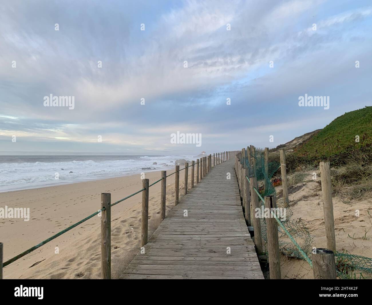 View of the wooden walk path on a cloudy day on the beach Stock Photo ...
