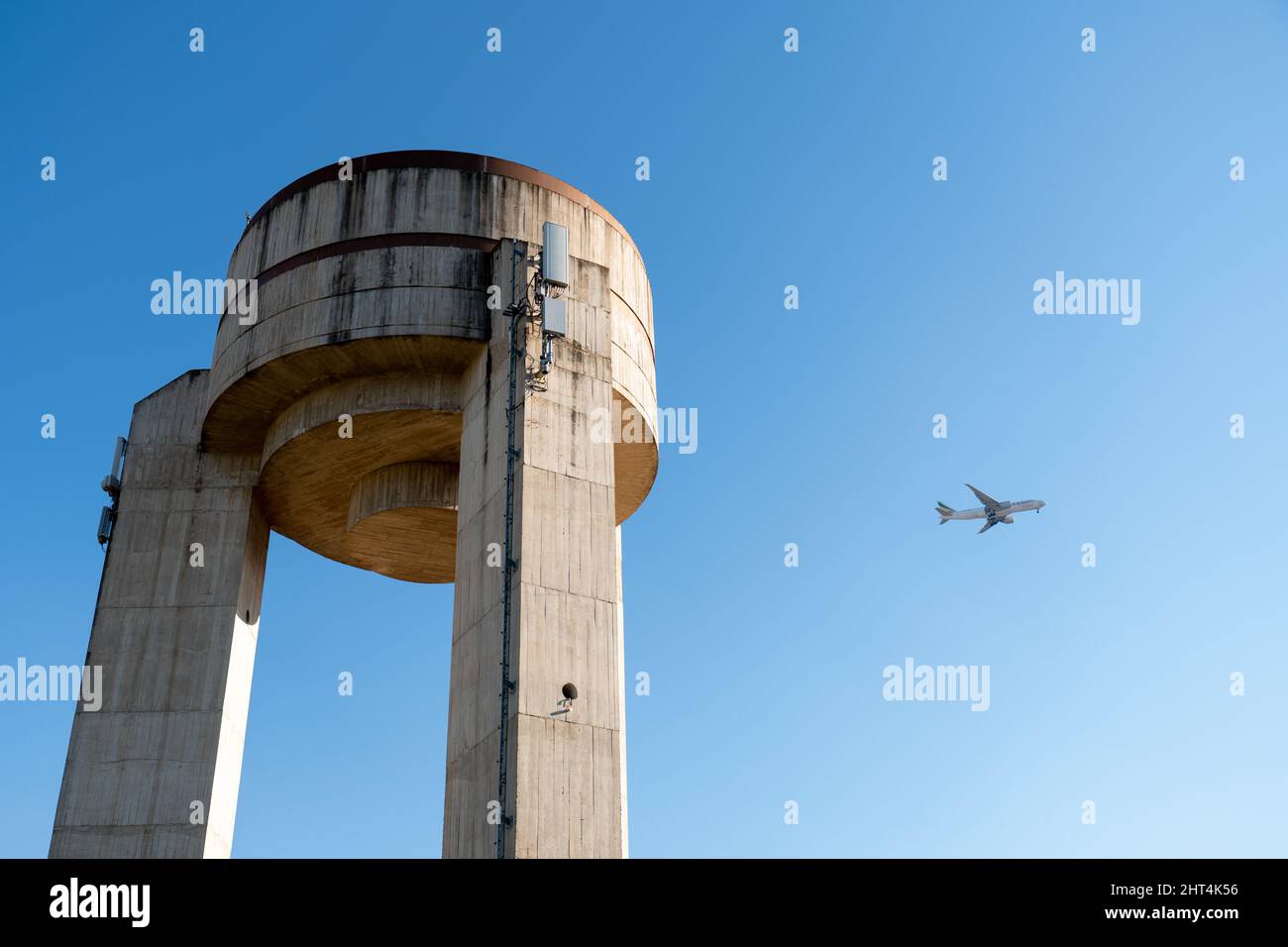 Airplane in the sky with a water tank made of concrete in the ...