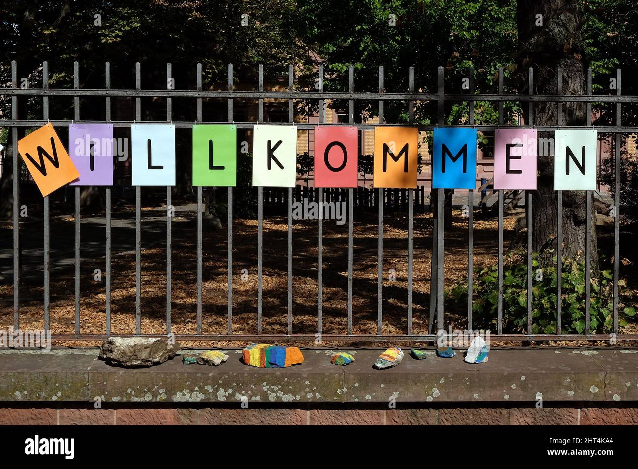 ''WILLKOMMEN'' writing on a separate colorful paper on a metal gates ...