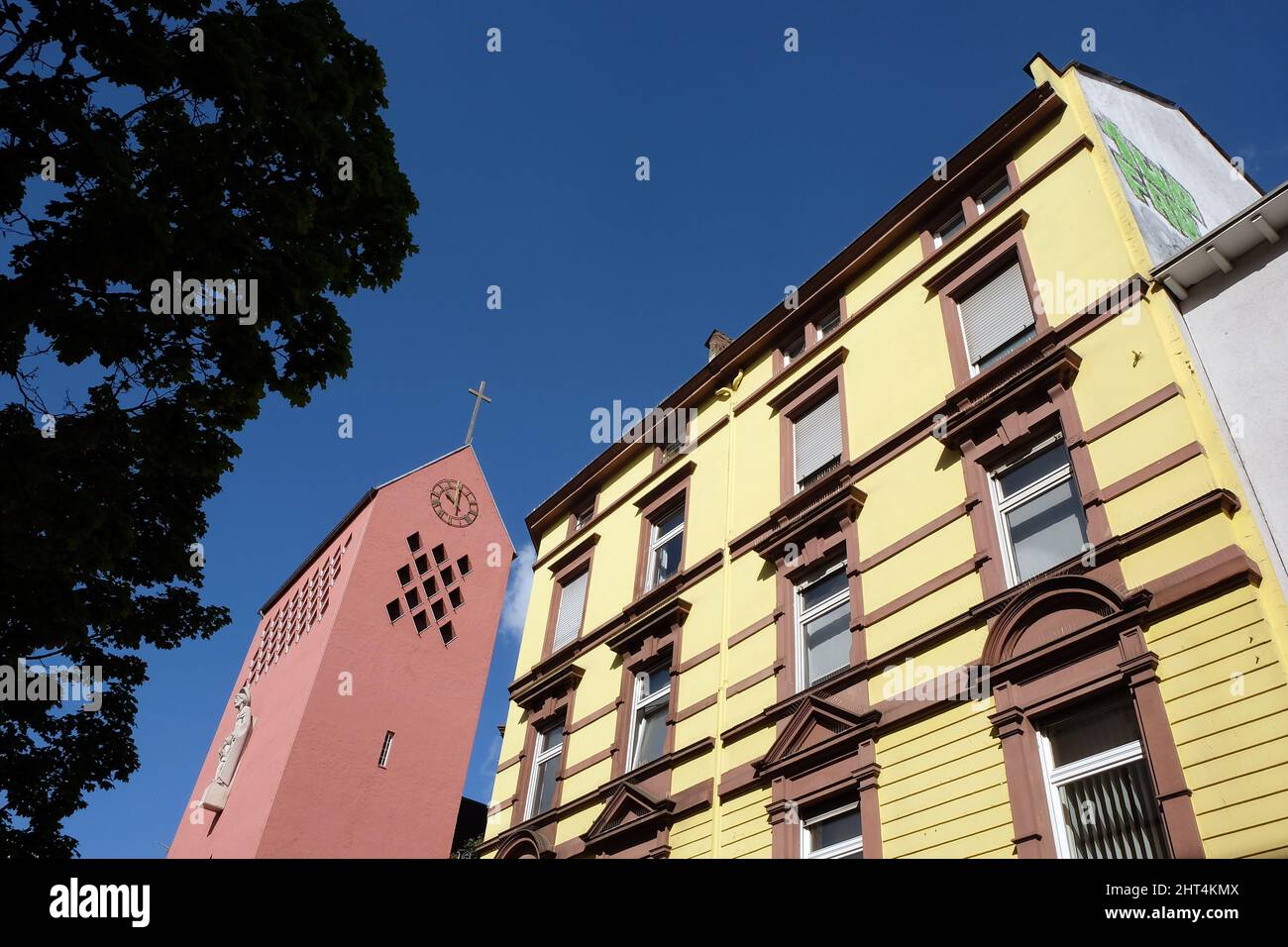 Church tower of the Catholic Church of St. Josef and the old yellow ...