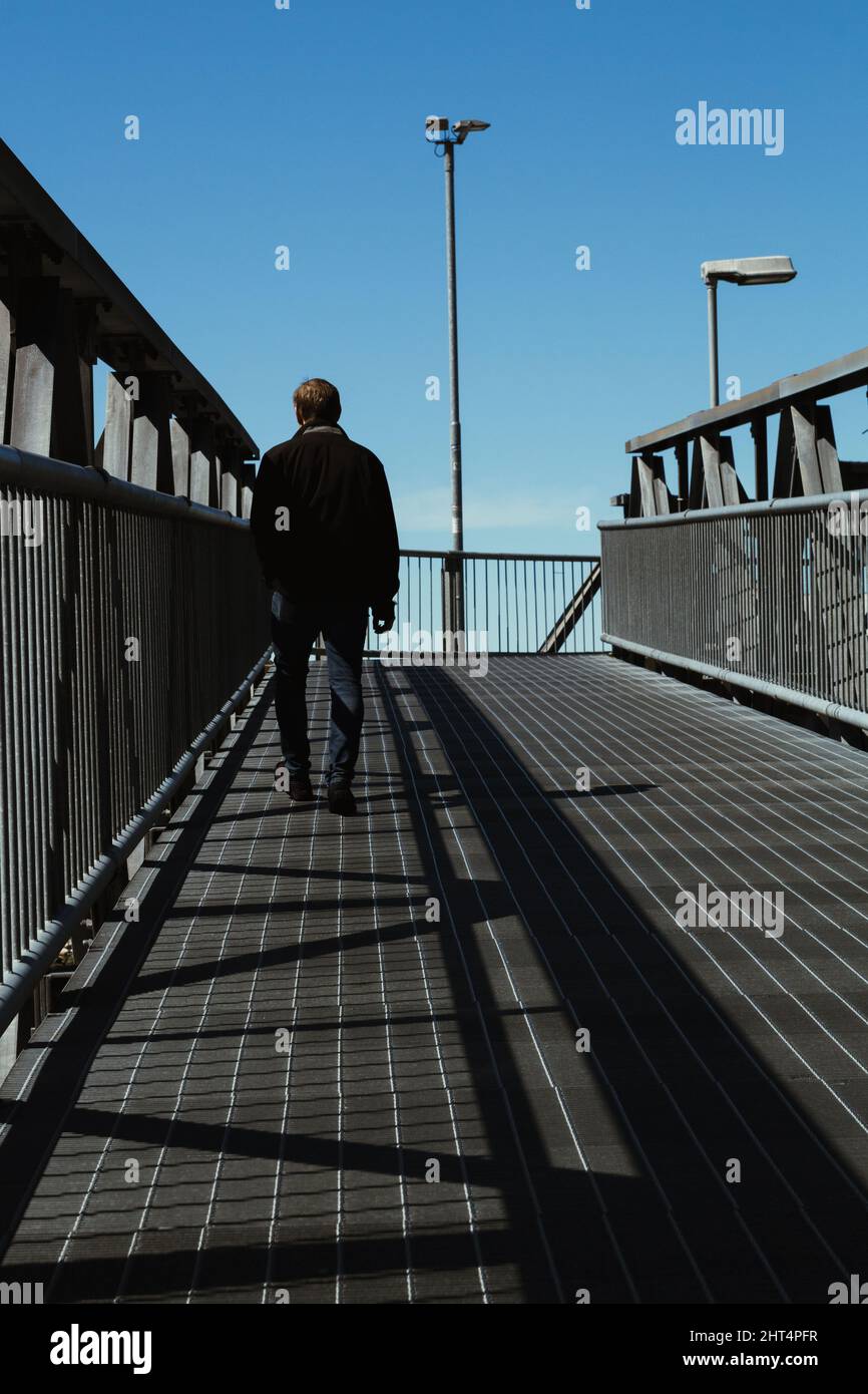 Back view of a male on the bridge Stock Photo - Alamy