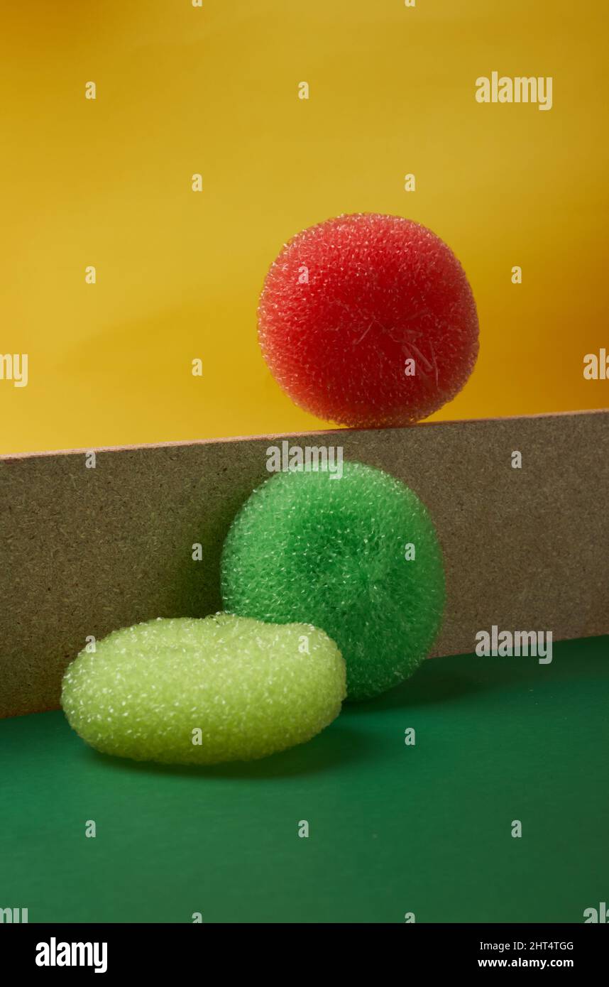 Vertical shot of three sponges for washing dishes with yellow and green ...