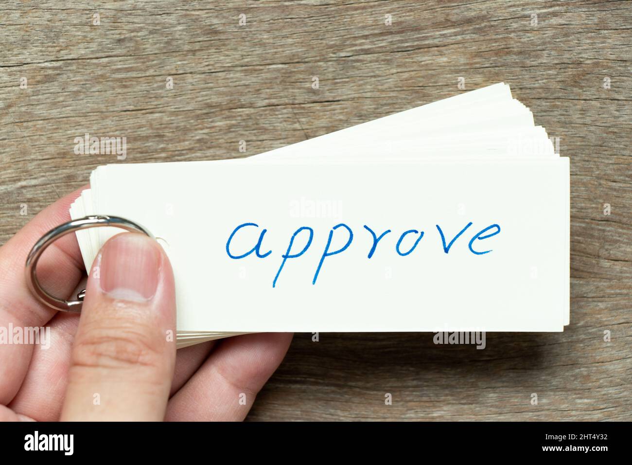 Man hold the flash card with handwriting word approve on wood ...