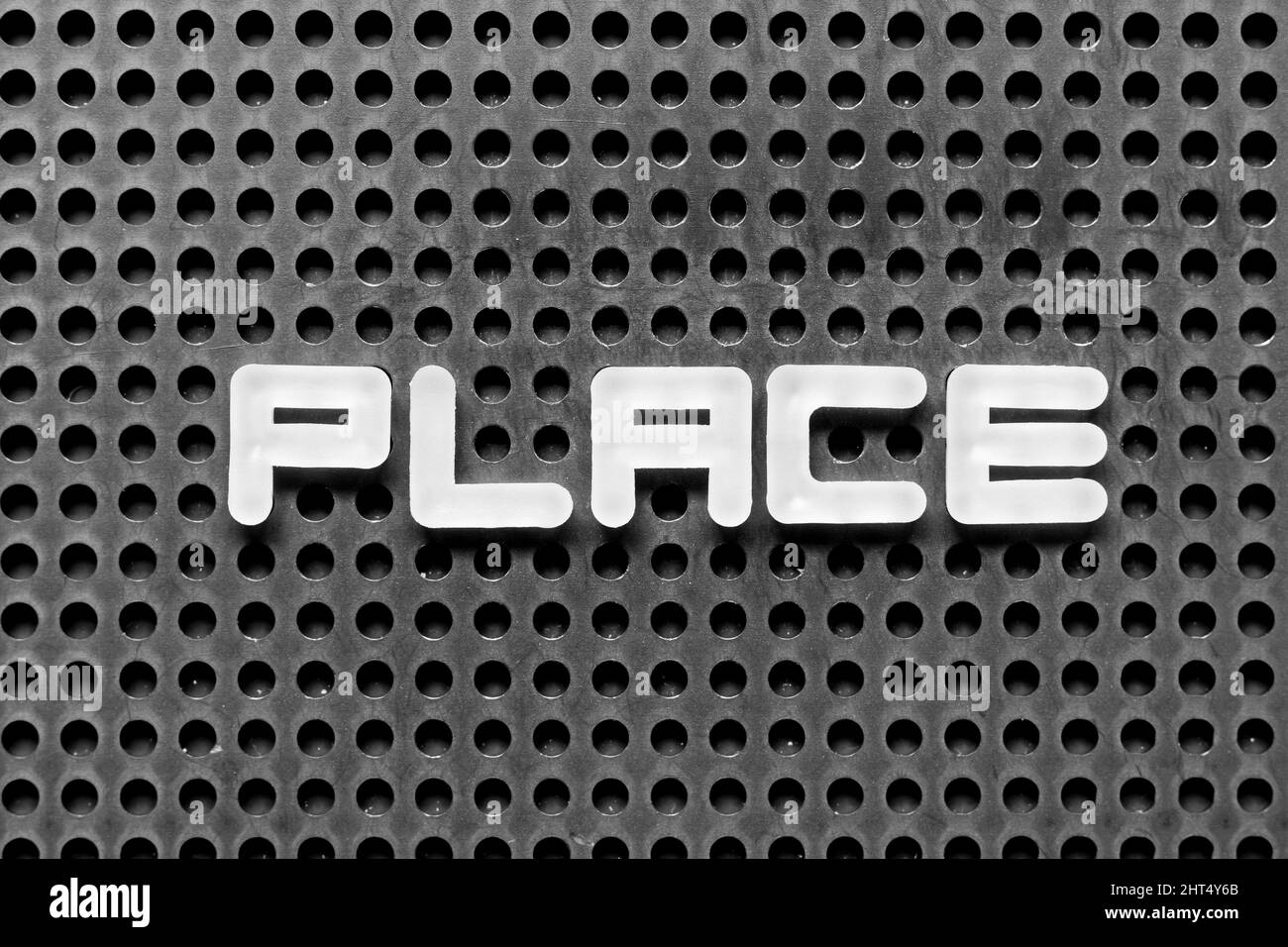 White alphabet letter in word place on black pegboard background Stock ...