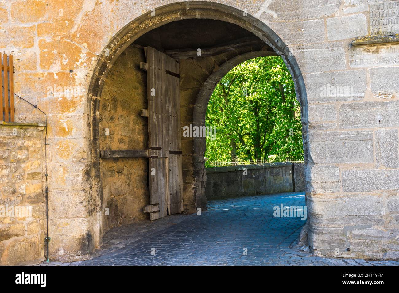 Medieval arch with tree view at a pretty cobbled street Stock Photo - Alamy