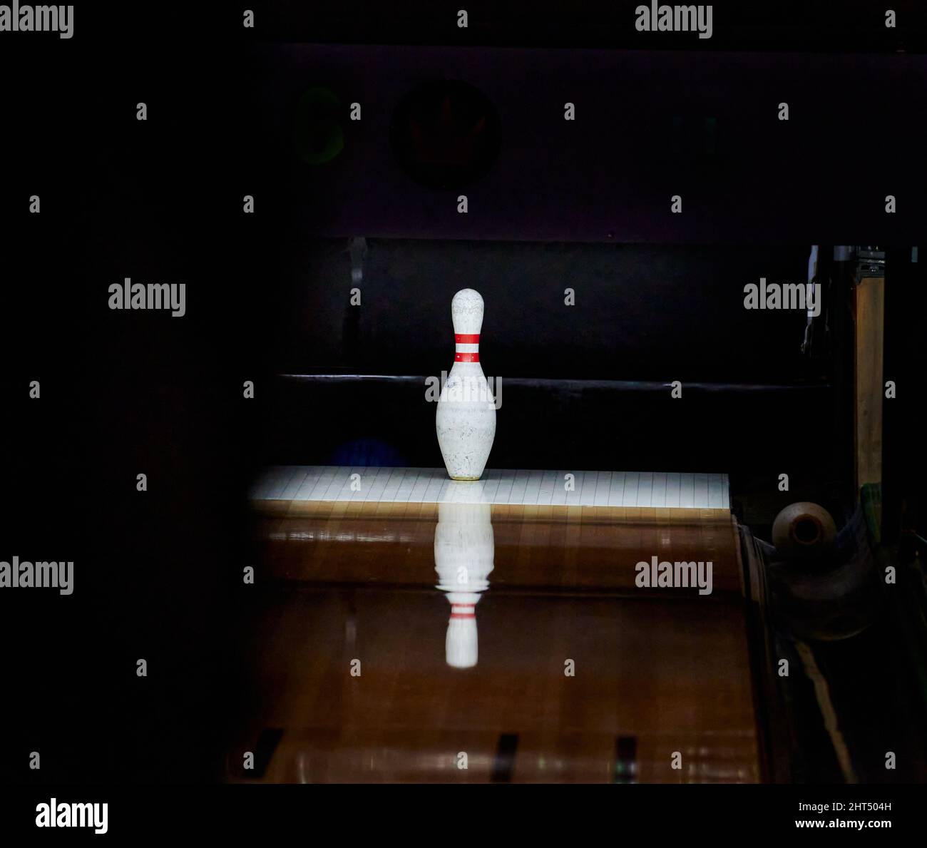 Closeup of a single bowling pin standing on the end of a lane Stock ...