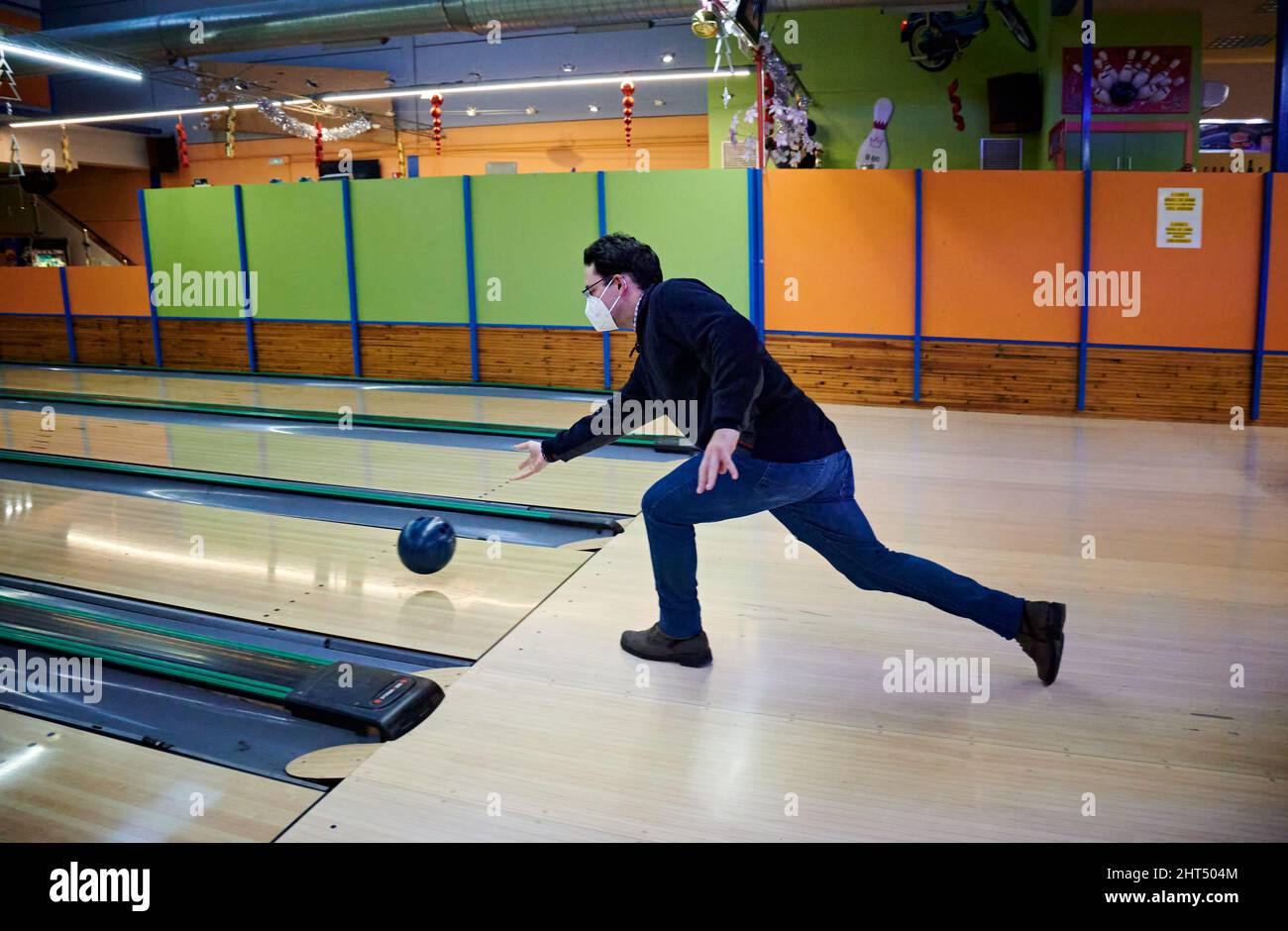 Photo of a Caucasian man throwing a bowling ball in a bowling hall ...