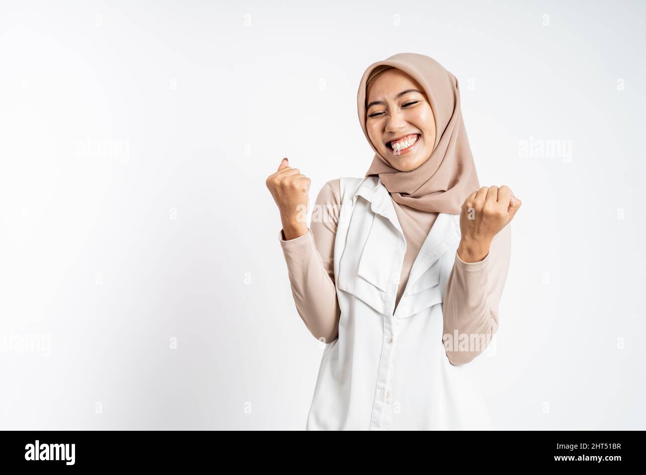 woman in hijab clenching hands while celebrating success Stock Photo ...