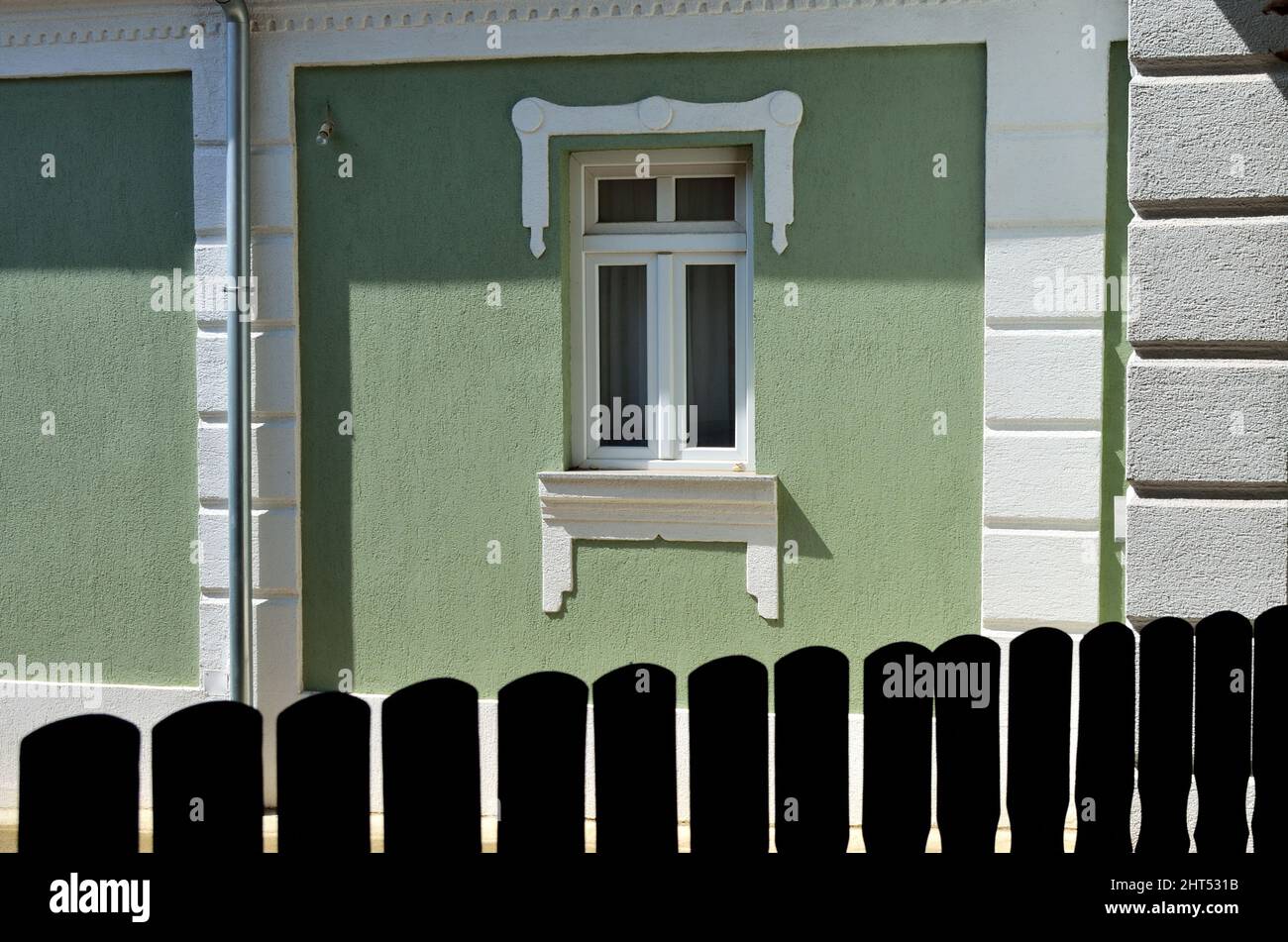 Window on a green building behind fence shadow Stock Photo - Alamy