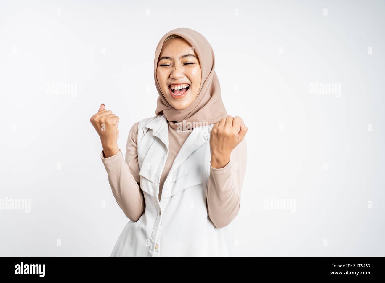 woman in hijab clenching hands while celebrating success Stock Photo ...